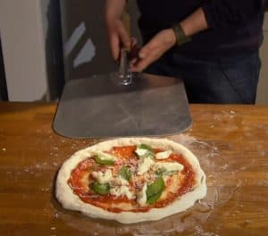 Move the shaped pizza quickly, before it sticks to the counter